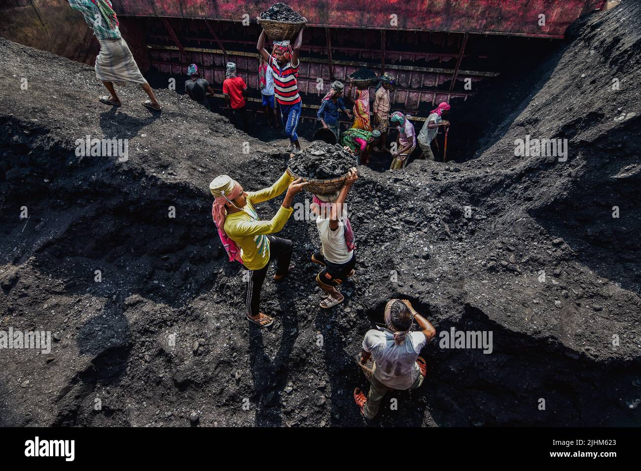 Women workers carrying baskets filled with coal on their head in the ...