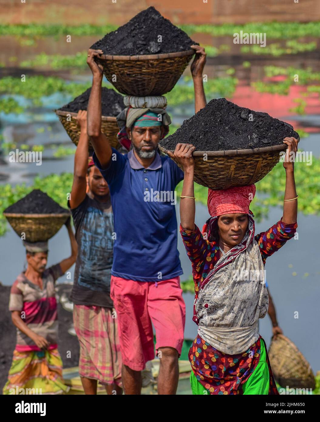Women workers carrying baskets filled with coal on their head in the ...