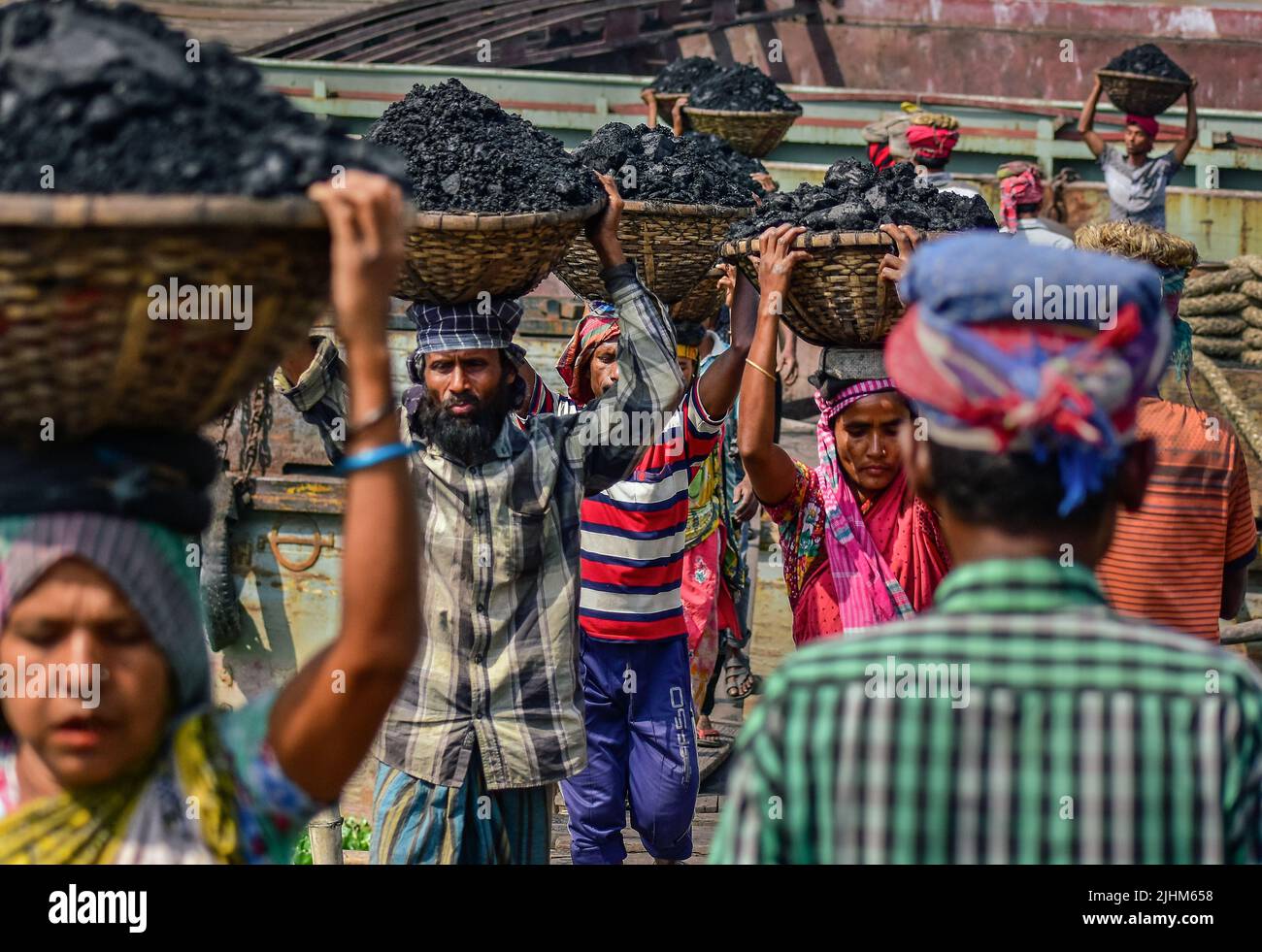 Women workers carrying baskets filled with coal on their head in the ...
