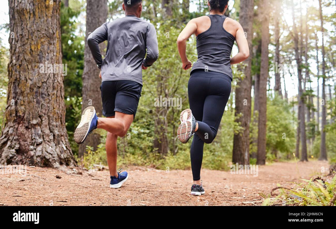 Fit male and female athletes running in nature. Young sportspeople ...