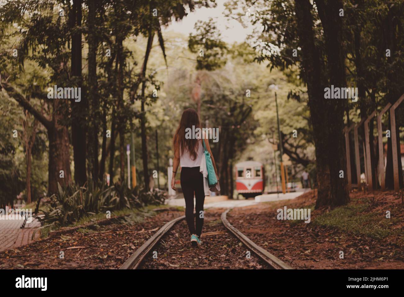 back view of a girl walking in the railway to catch the train Stock ...