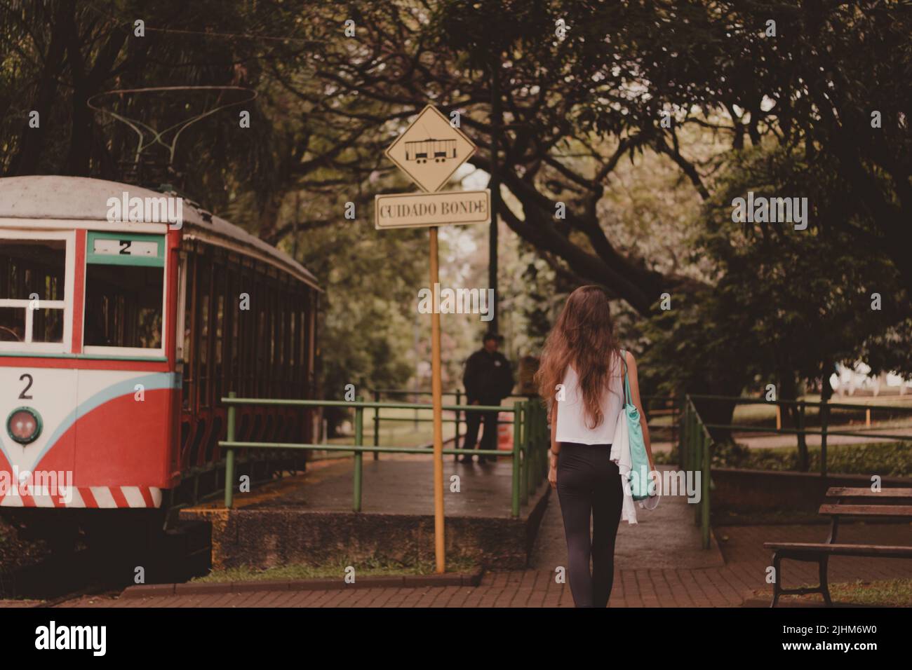 back view of a woman walking to catch the tram Stock Photo - Alamy