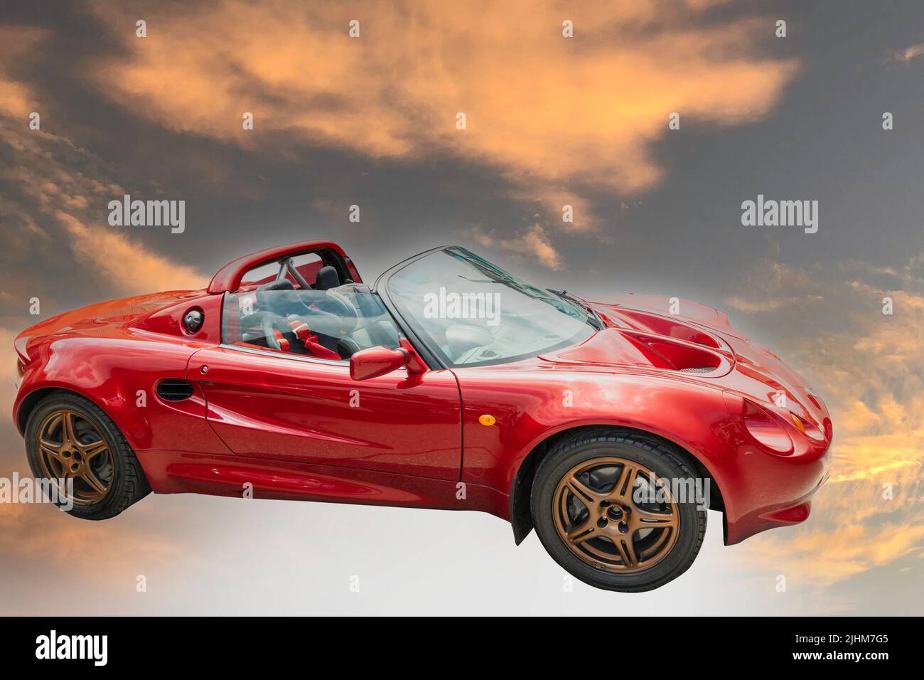 Two-seater sports car with an open top against the background of red ...