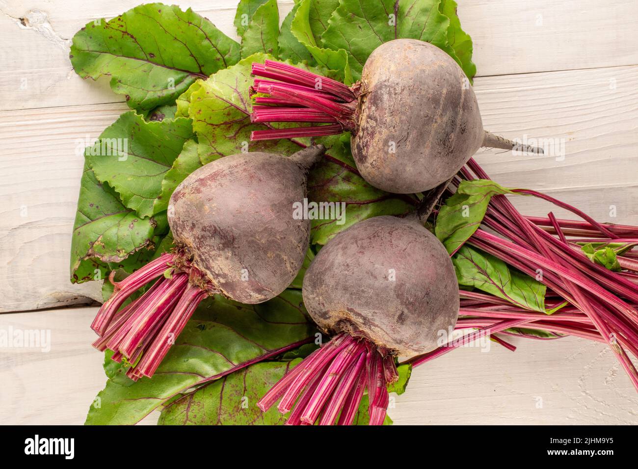 Three sweet red beets on a wooden table, close-up, top view Stock Photo ...