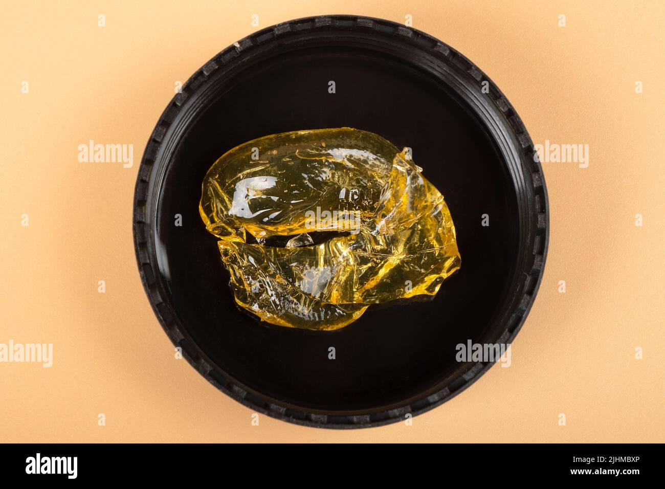 golden cannabis wax in a glass container, high thc dab in glass bottle ...