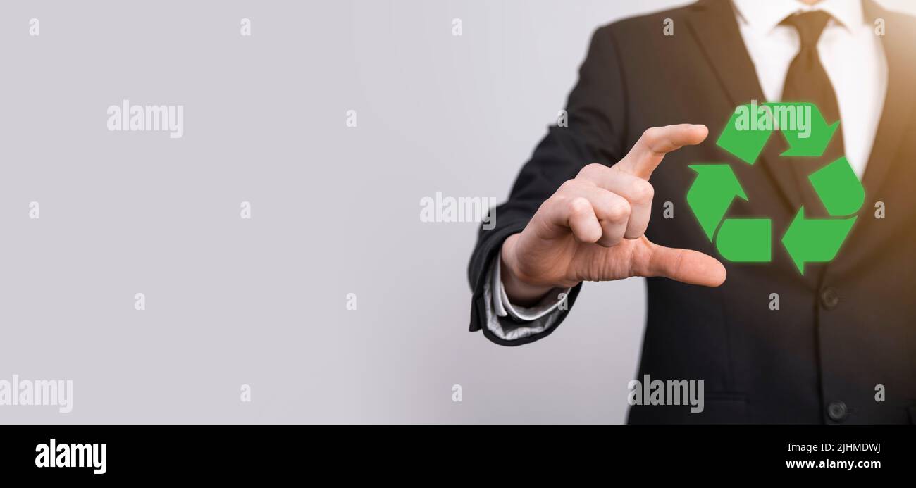 Businessman in suit over grey background holds an recycling icon, sign ...