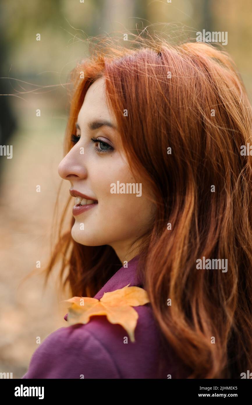 Mental health in autumn. Happy red-haired woman holding yellow maple ...
