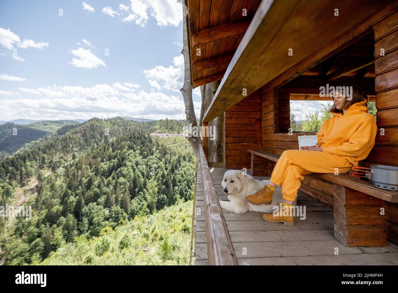 Woman sits relaxed with her dog in the mountains Stock Photo - Alamy