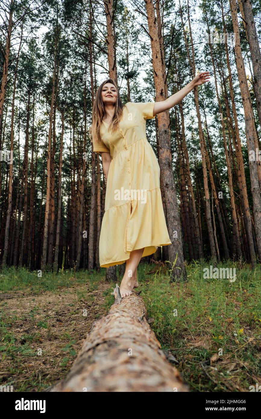 Peace of mind, breathing fresh air. Alone woman in dress lying on tree ...