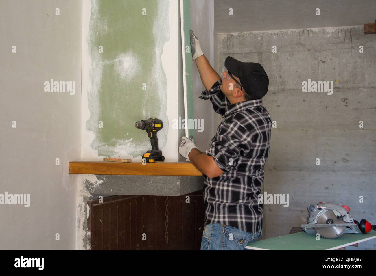 Image of a handyman installing drywall panels. Do-it-yourself manual ...