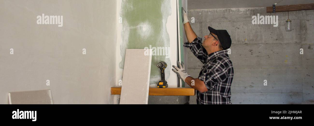 Image of a handyman installing drywall panels. Do-it-yourself manual ...
