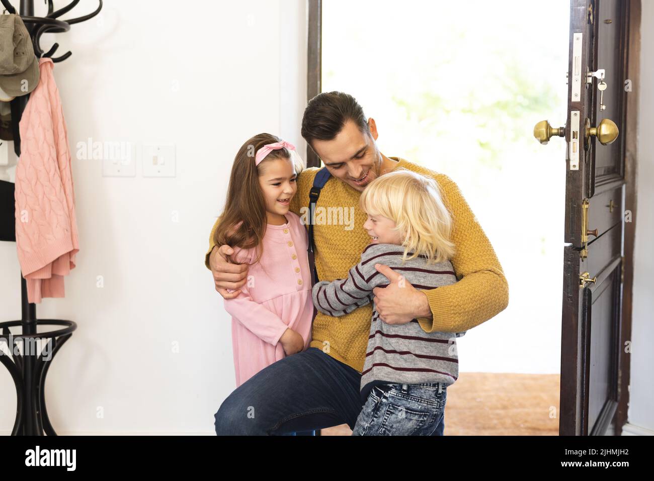 Image of caucasian father returning home from work and welcoming with ...