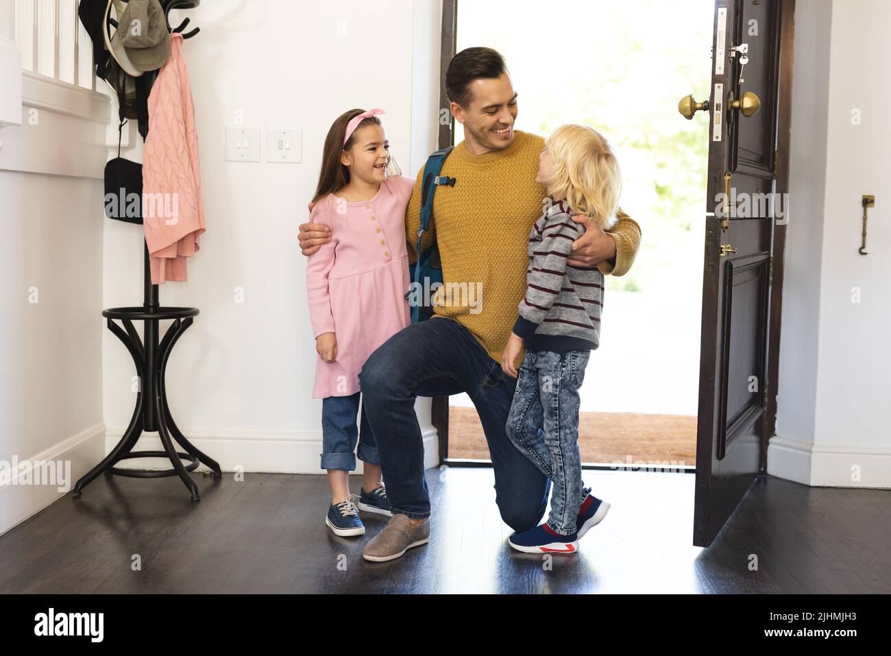 Image of caucasian father returning home from work and welcoming with ...