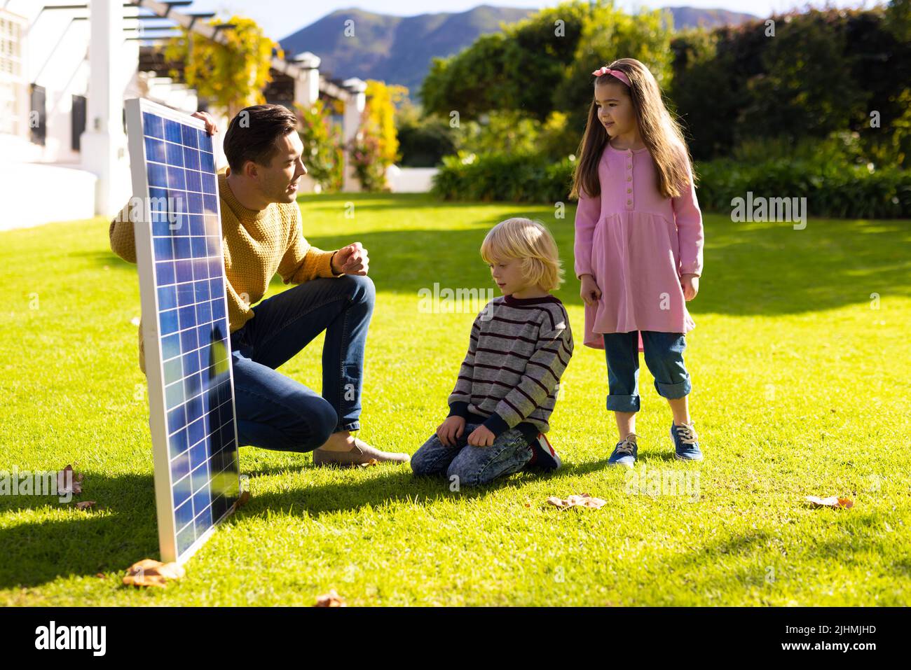 Image of caucasian father showing solar panel to children Stock Photo ...