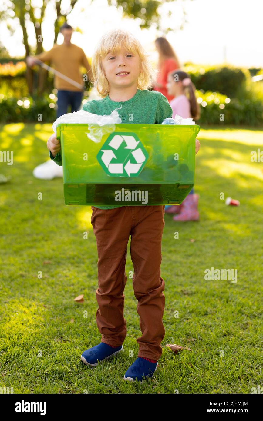 Vertical image of caucasian boy with box for waste recycling Stock ...