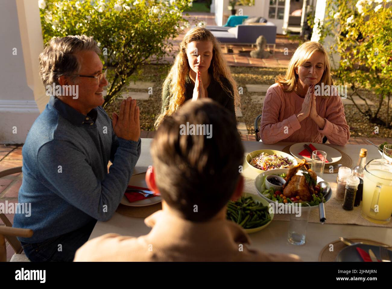 Image of multi generation caucasian family praying before outdoor ...