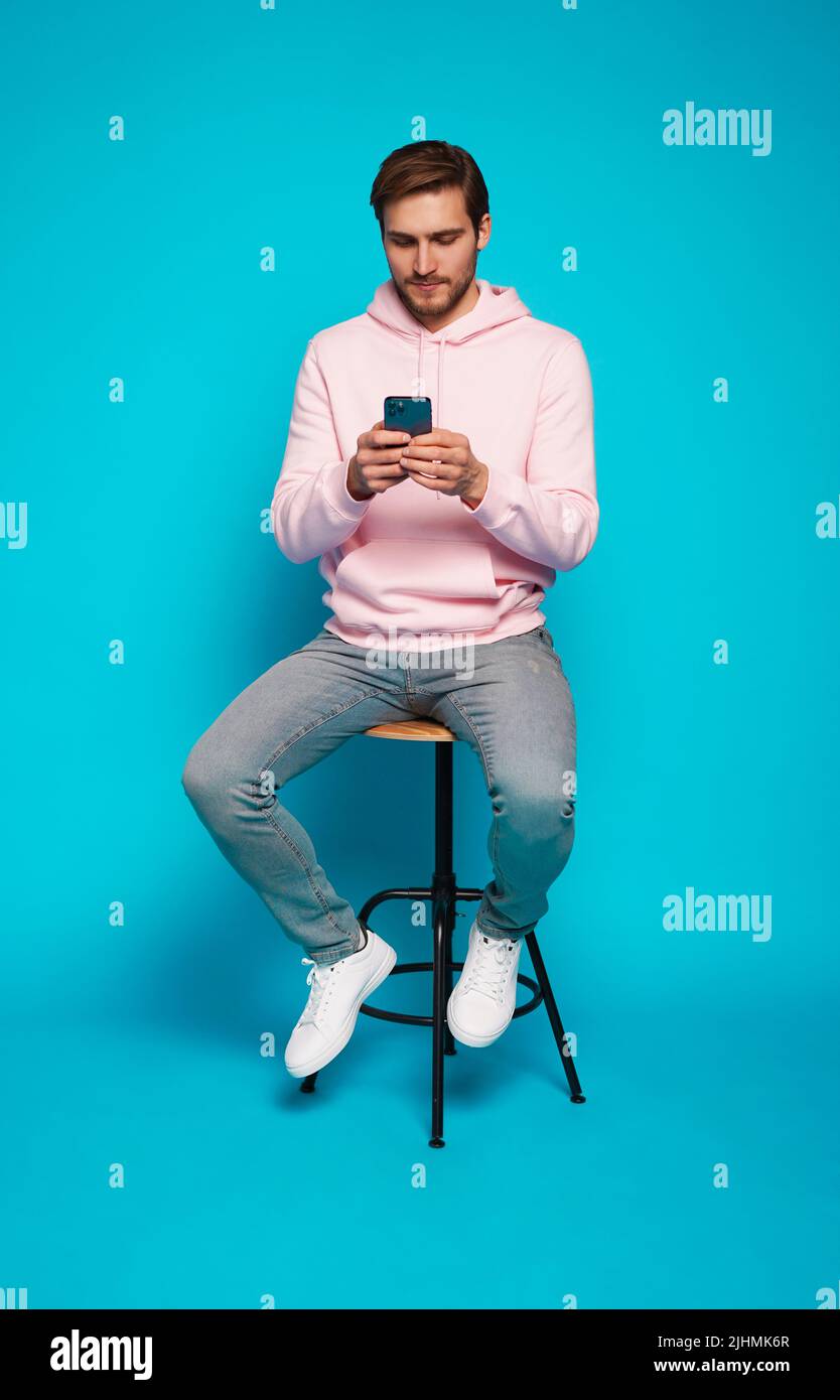 Attractive man chatting or typing text message using cell phone ...
