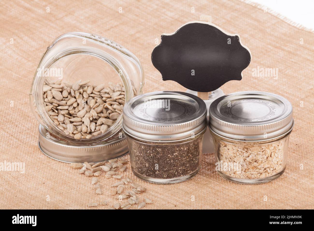 Three glass containers with different seeds: chia, sunflower seeds and ...
