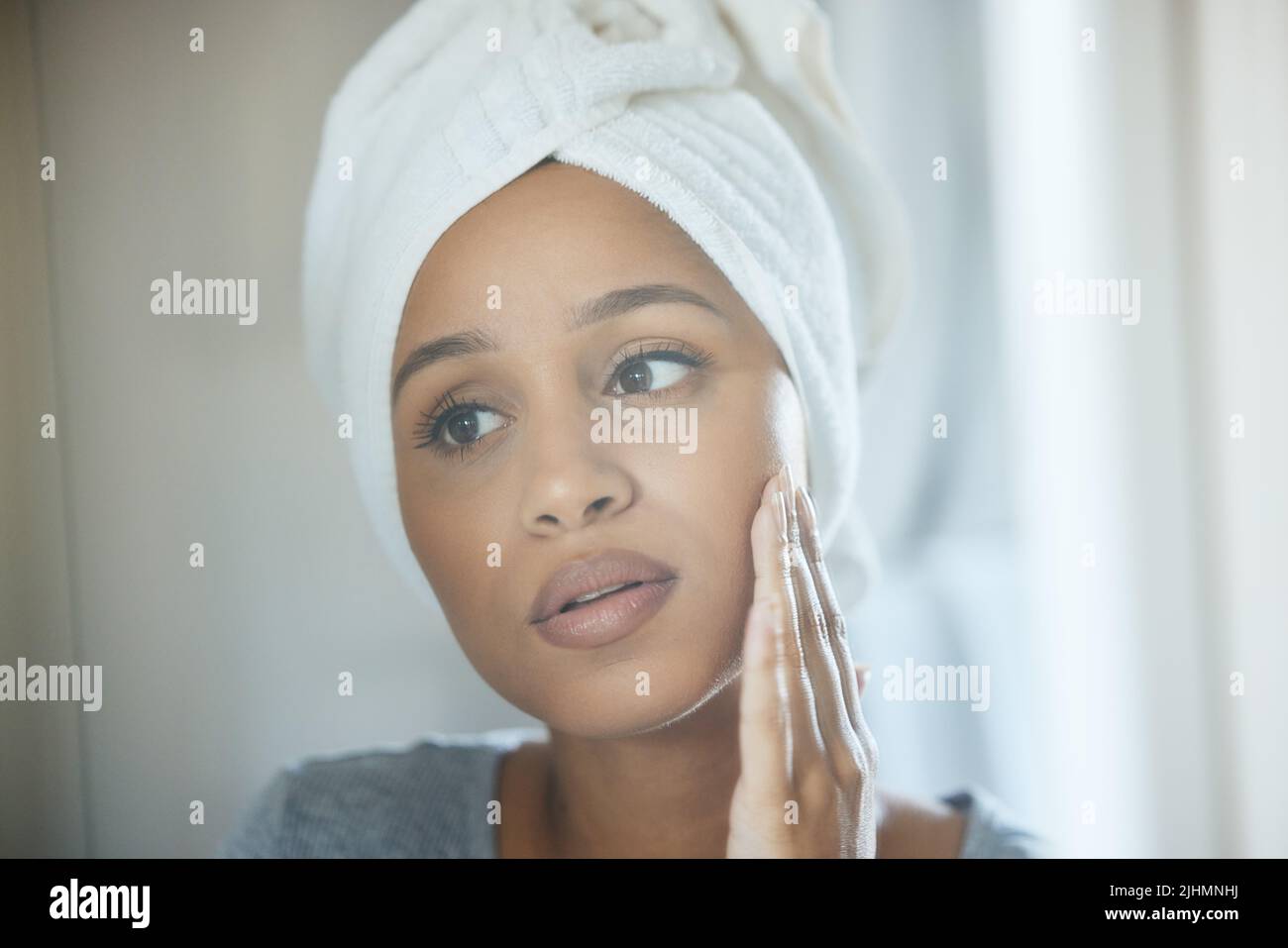 Embrace your natural beauty. a young woman getting ready in a bathroom ...