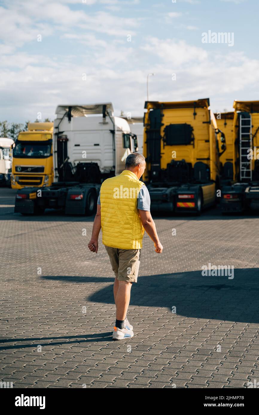 Portrait of caucasian mature man on semi-truck vehicles parking ...