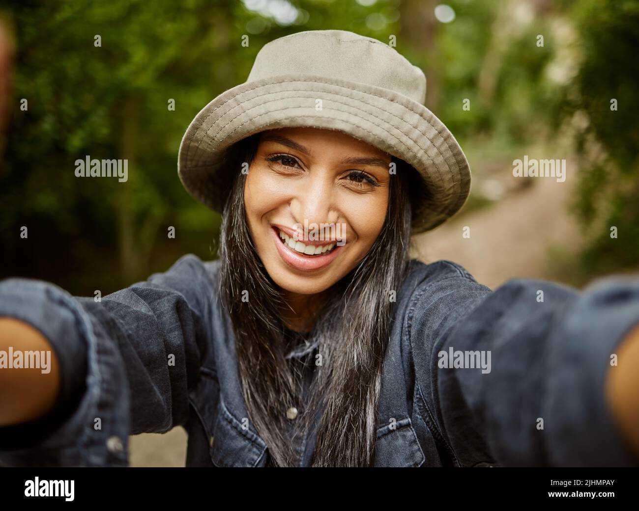 Selfies in nature. Cropped portrait of an attractive young woman taking selfies while hiking in ...
