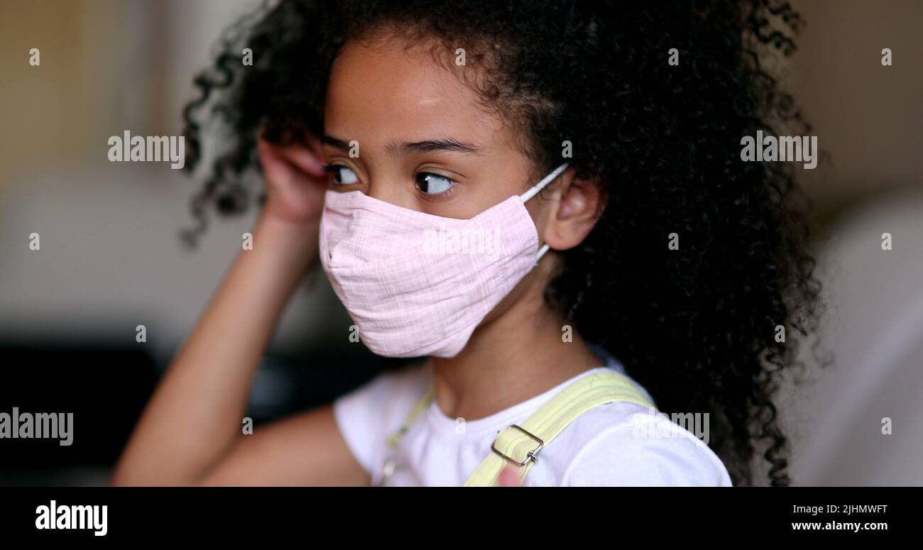 Little girl wearing covid-19 face mask. Portrait kid putting mask on ...