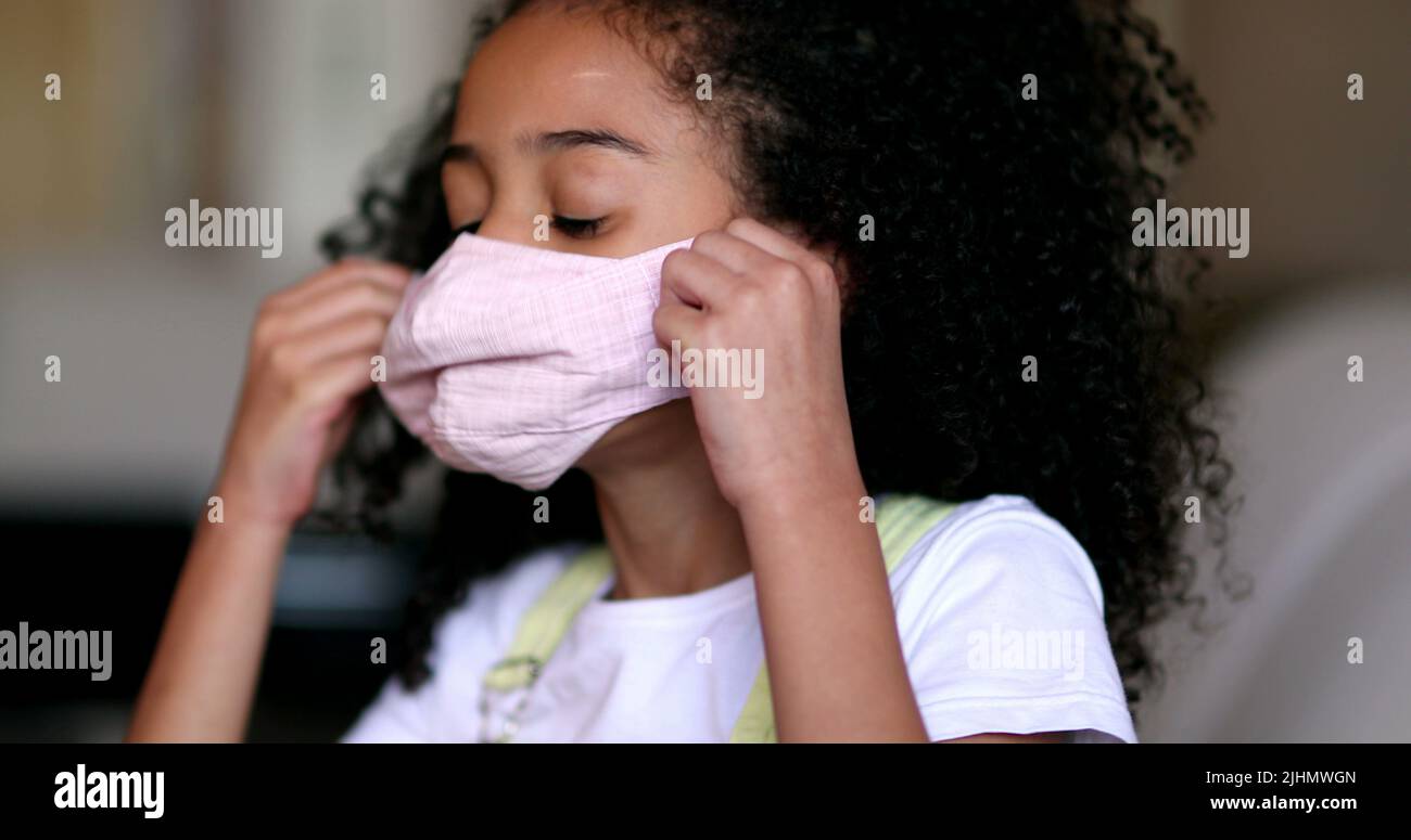 Little girl wearing covid-19 face mask. Portrait kid putting mask on ...