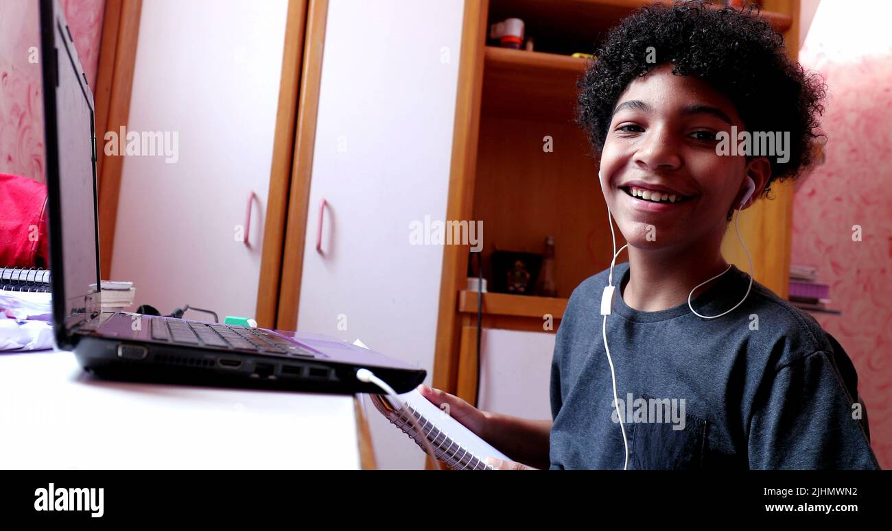 Mixed race boy writing notes on notepad at home doing homework Stock ...