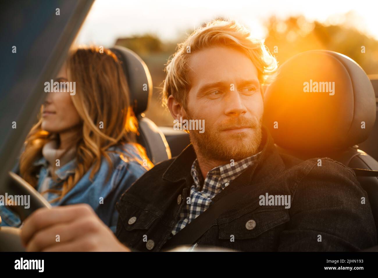 White mid couple driving together in car on sunset during trip Stock ...