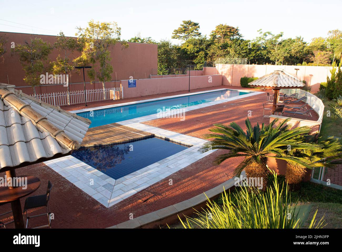 Beautiful leisure area with a huge blue tile pool in the late afternoon ...