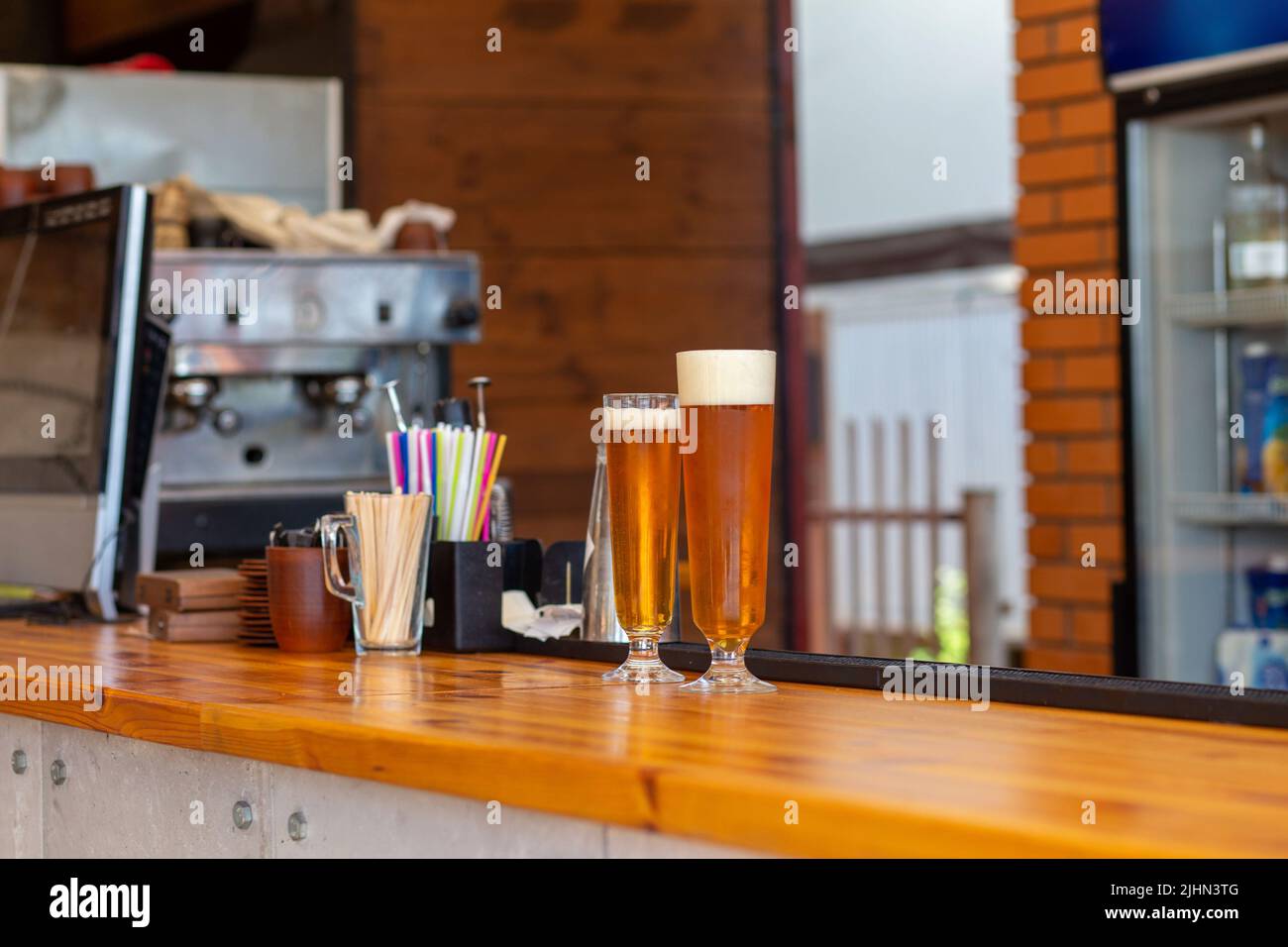 Two glasses of beer placed on bar counter. Still life in a bar interior ...