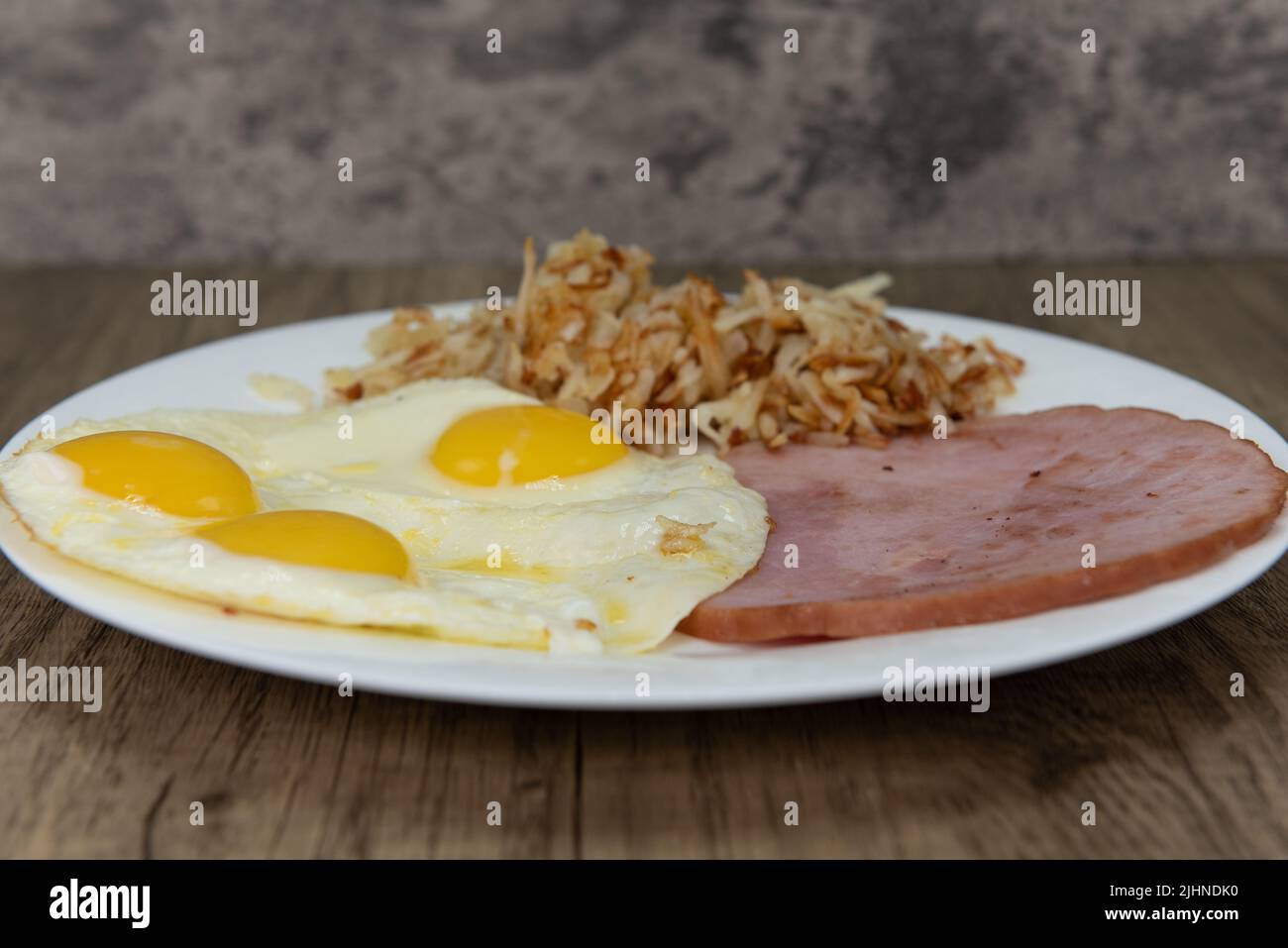 Standard American breakfast consisting of ham, fried eggs, and hash ...