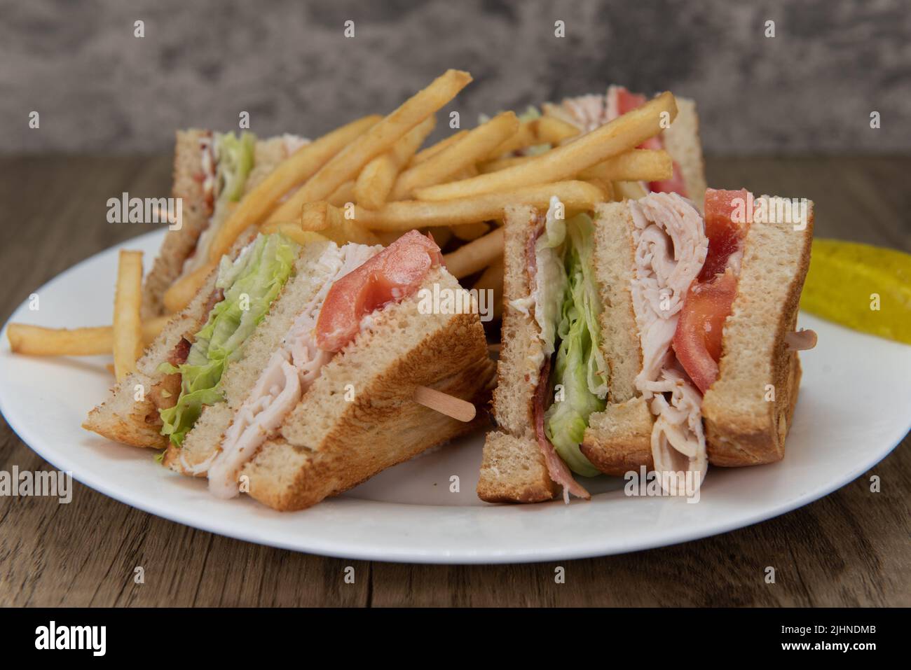 Loaded turkey club sandwich, cut into 4 wedges and covered in french ...
