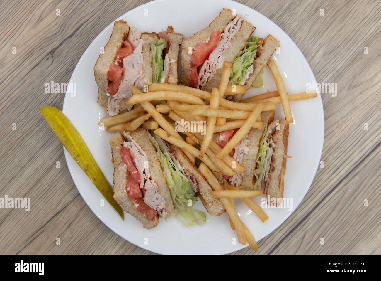 Overhead view of loaded turkey club sandwich, cut into 4 wedges and ...