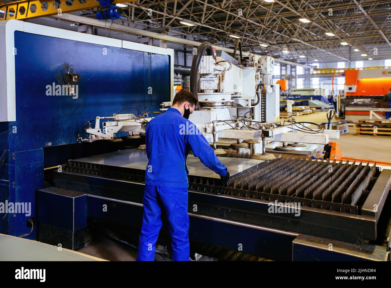 Worker puts steel sheet into loading unit of cutting machine Stock ...