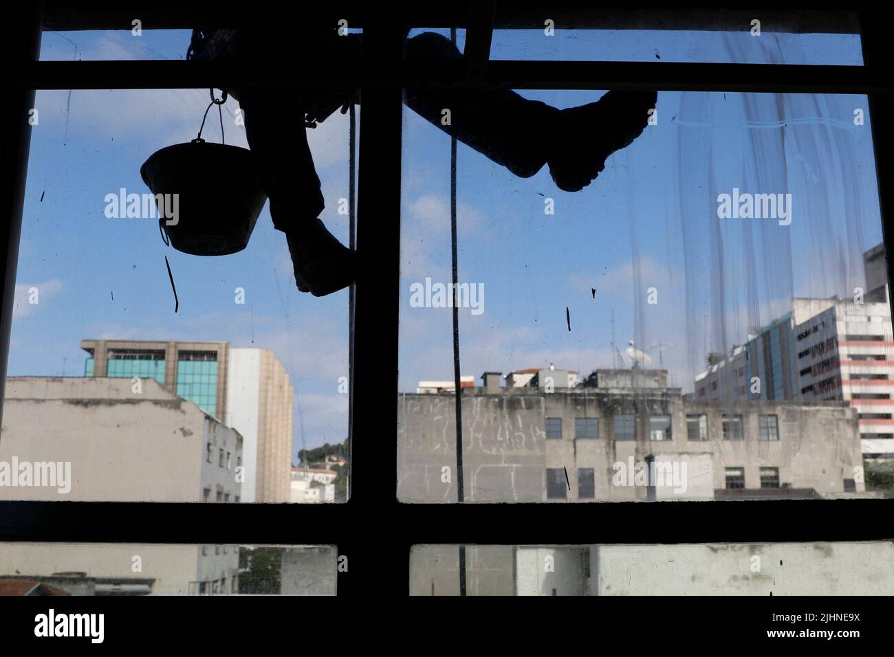 Rappeling man work on external window cleaning service and building ...