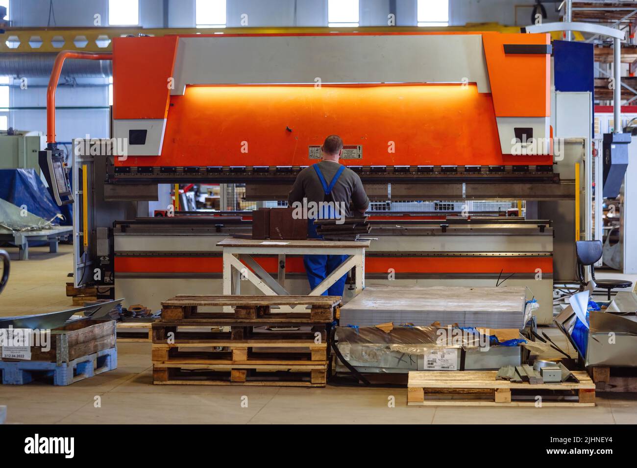 Technician operator working with with sheet metal on CNC hydraulic ...