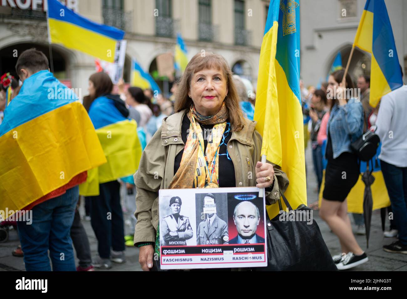 Protestor has sign which puts Vladimir Putin in a line with Benito ...