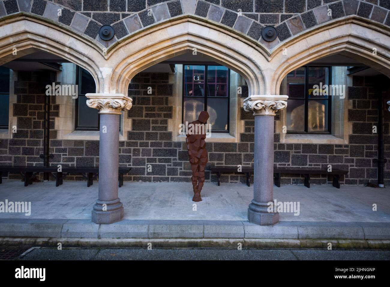 A rusted, iron sculpture stands in a covered colonade in the north quad ...