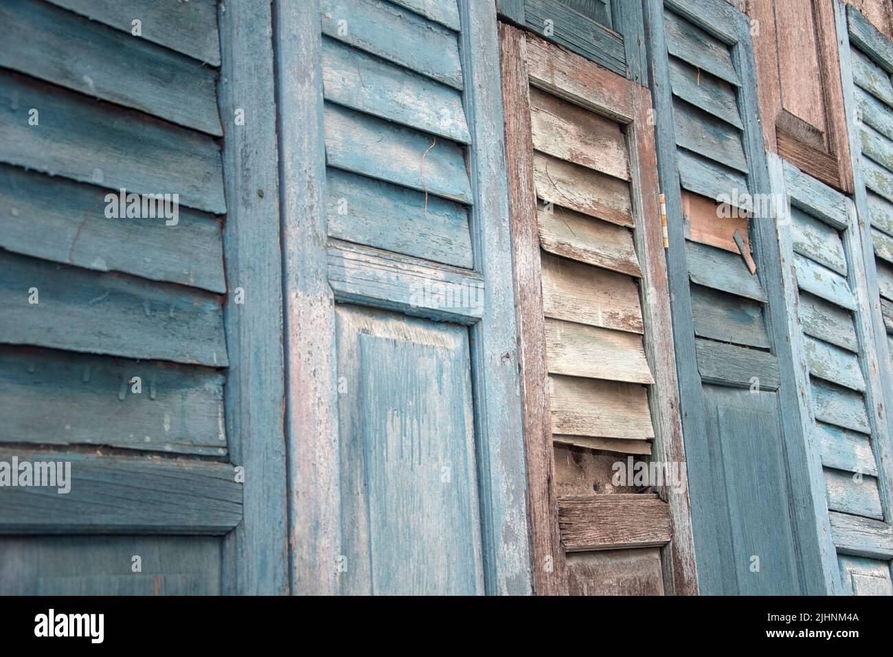 Wooden blue closed shutters on the window of an old traditional village ...