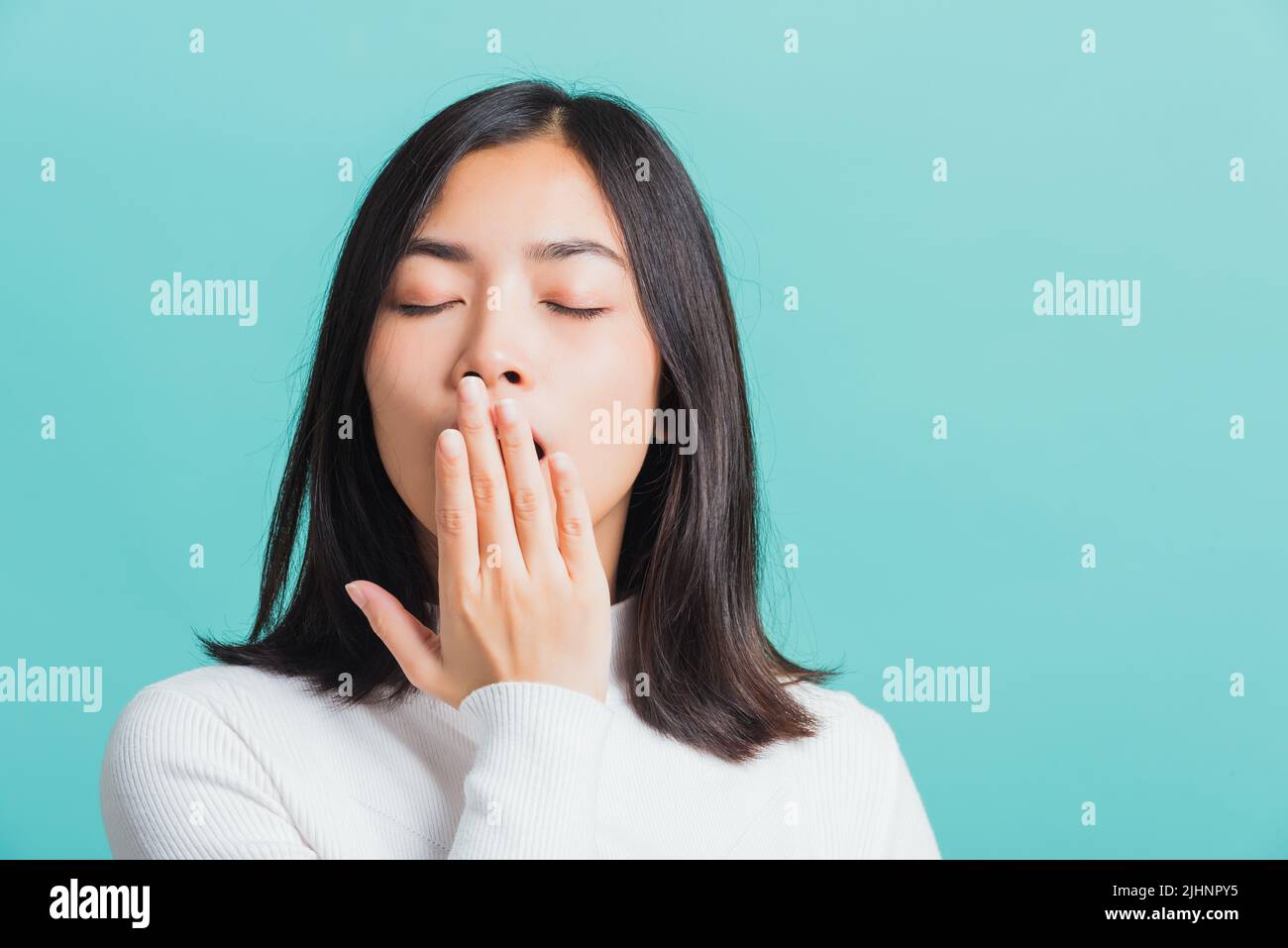 Portrait female bored yawning tired covering mouth with hand, Young beautiful Asian woman sleepy ...