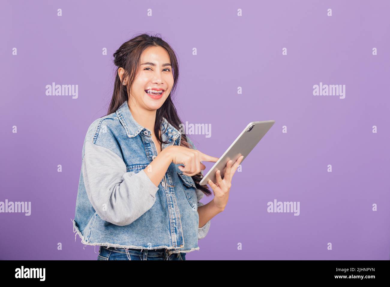 Portrait of Asian beautiful young woman smiling using tablet computer ...