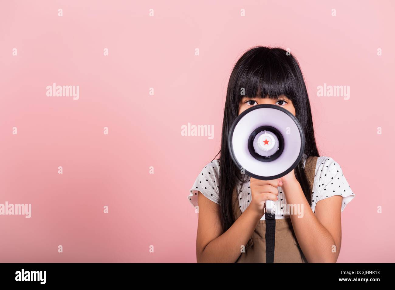 Asian little kid 10 years old shouting by megaphone at studio shot ...