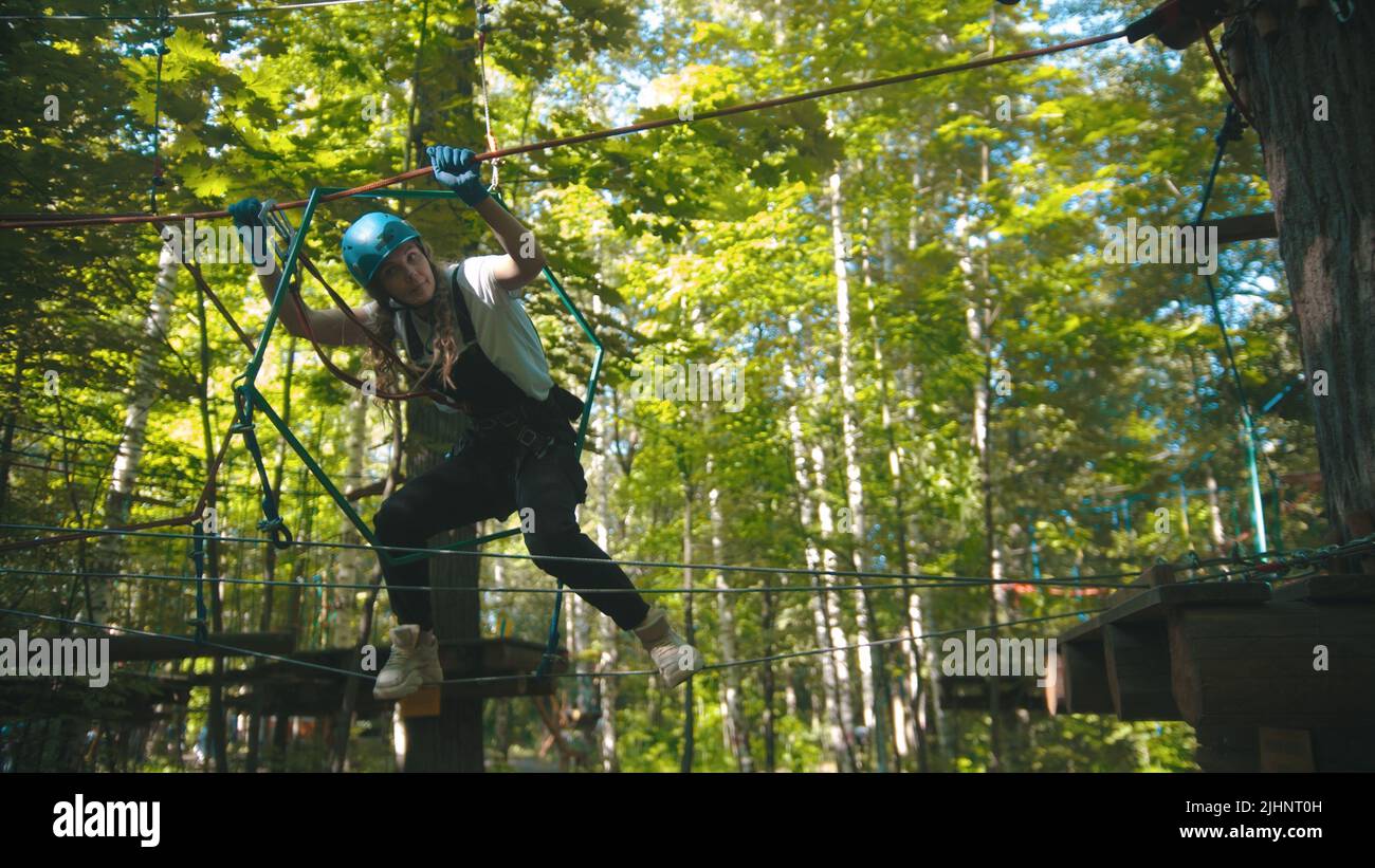 Woman crossing a rope bridge - an entertainment attraction in the ...