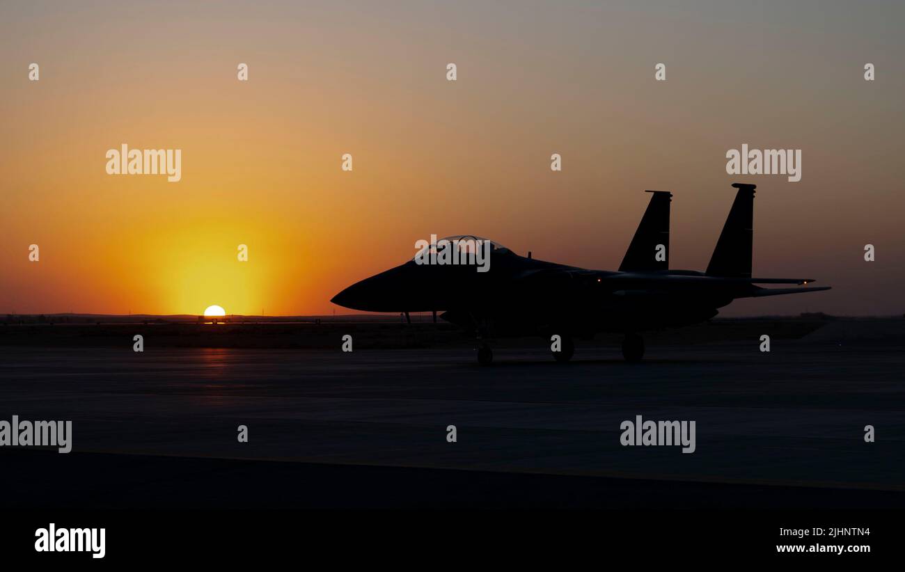 The F-15 E Strike Eagle prepares for flight during a sunset at an ...