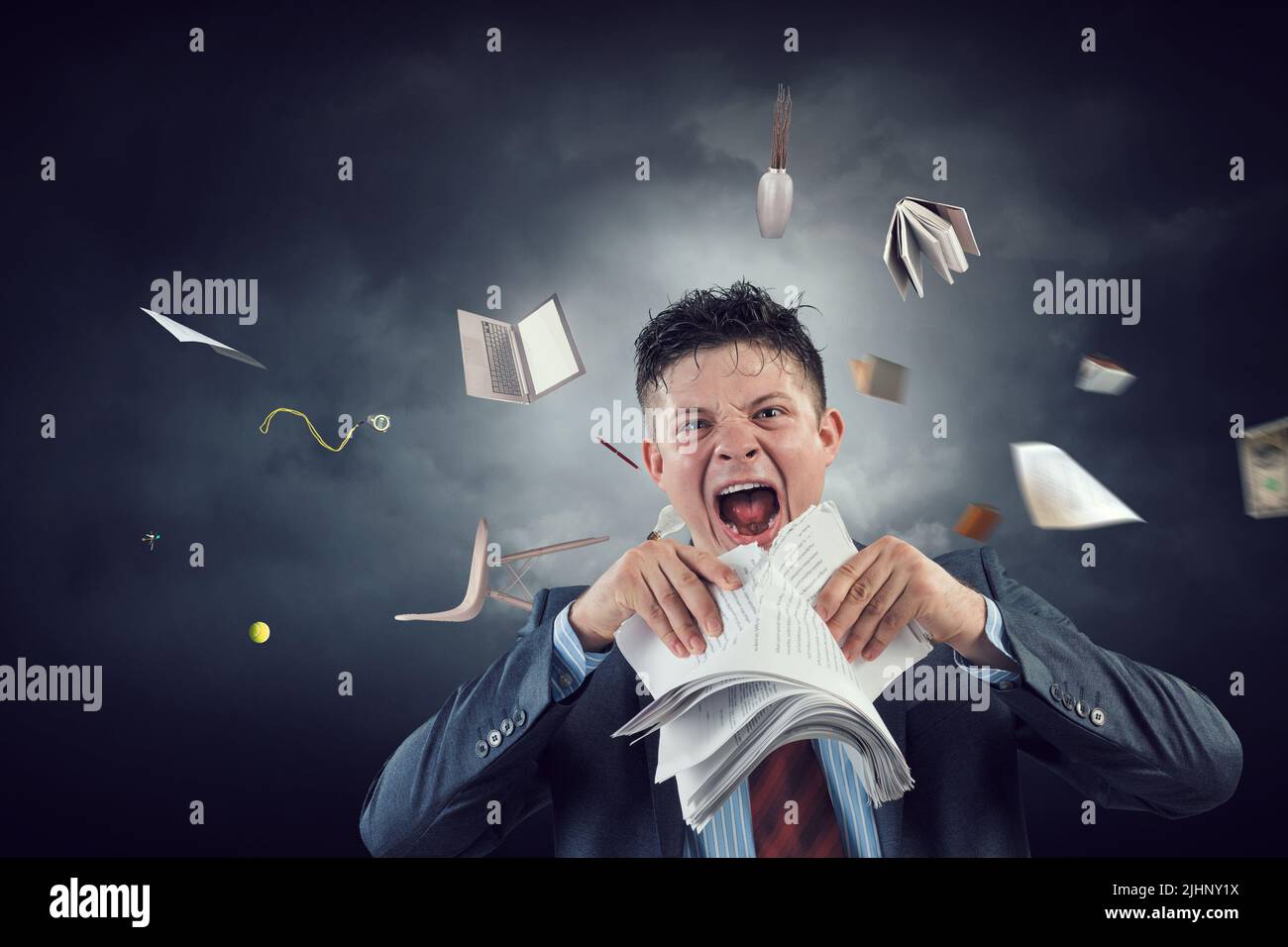 Young stressed man ripping documents with frustrated facial expression ...