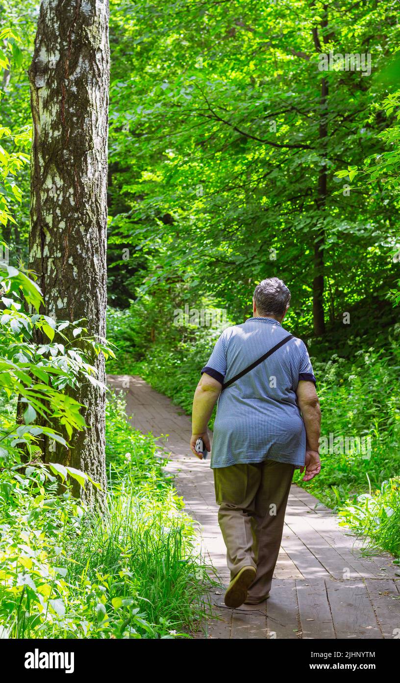Senior woman walking wooden path in forest,outdoor on amazing blurred ...