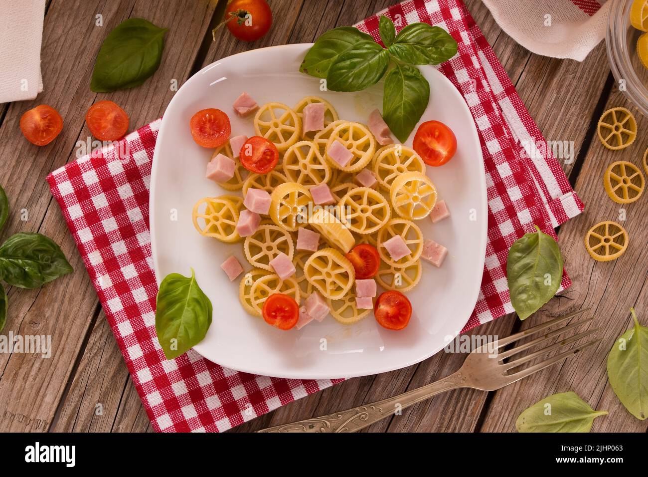 Ruote pasta with tomato and ham Stock Photo - Alamy