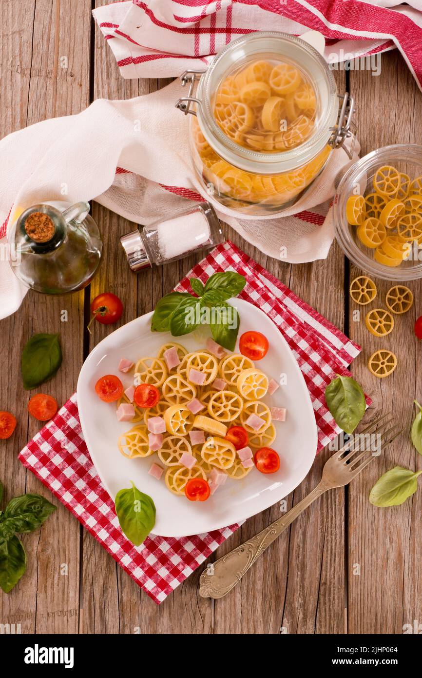 Ruote pasta with tomato and ham Stock Photo - Alamy