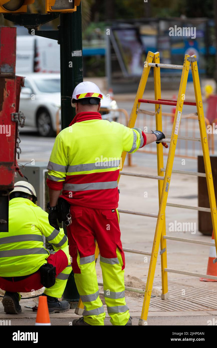 Two electrician worker fixing a traffic light in city street Stock ...